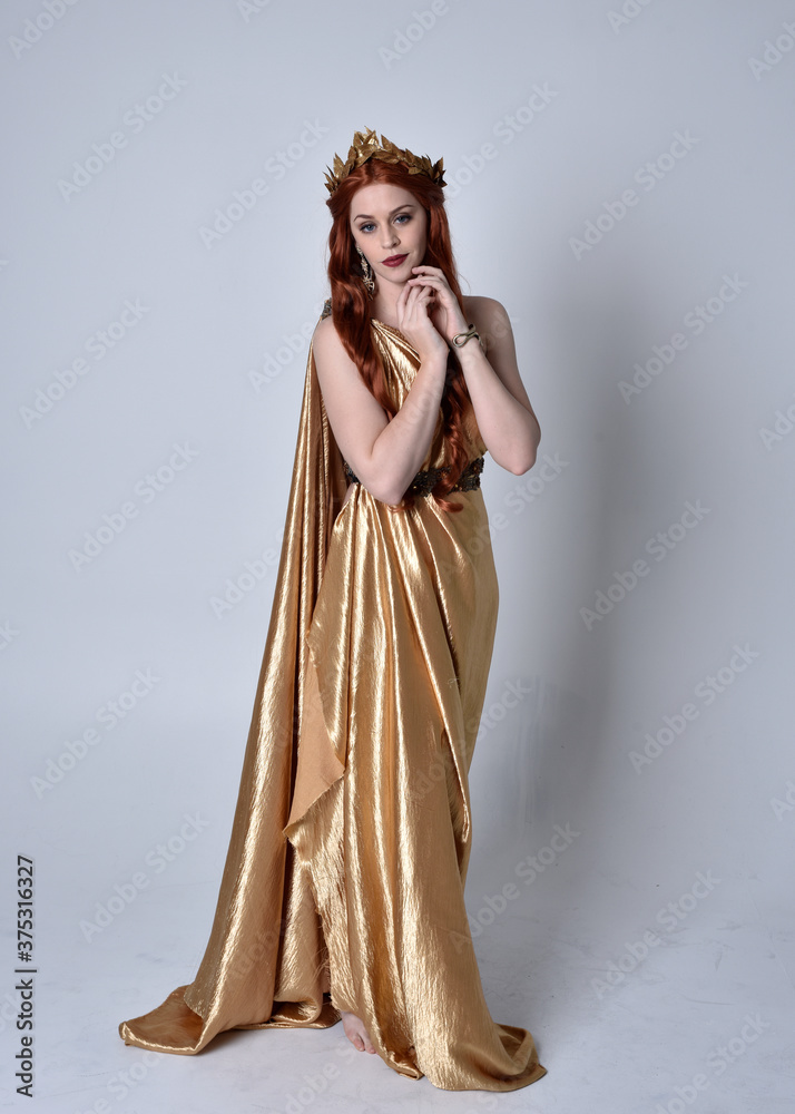 Full length portrait of girl with red hair wearing long grecian toga ...