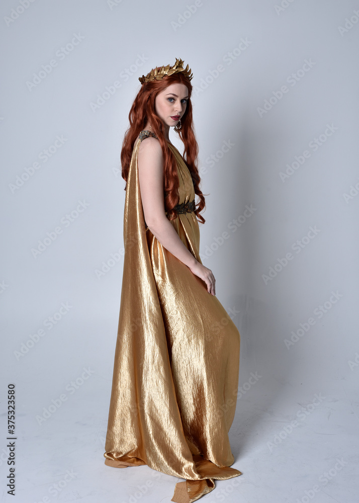 Full length portrait of girl with red hair wearing long grecian toga ...