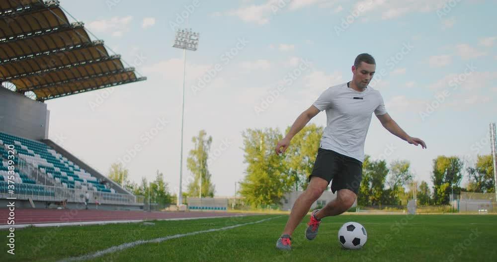 Vidéo Stock A soccer player at the stadium demonstrates dribbling with ...