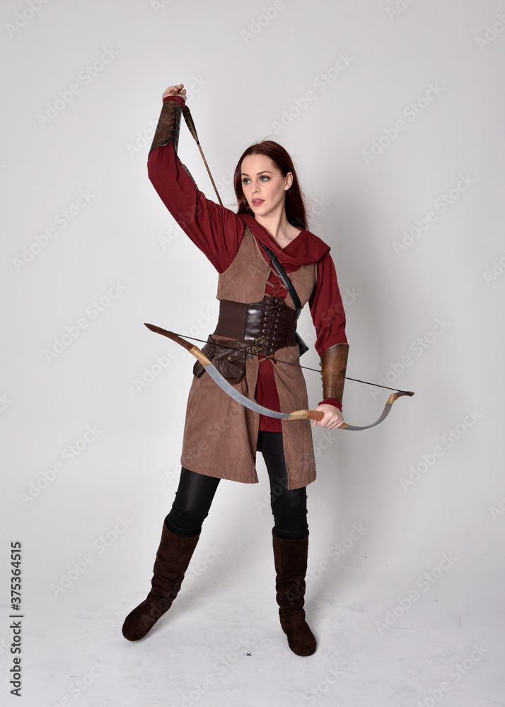 Full length portrait of girl with red hair wearing brown medieval ...
