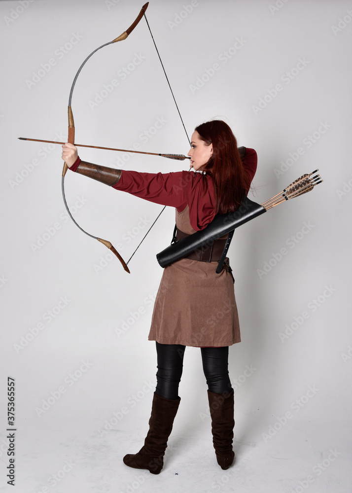 Full length portrait of girl with red hair wearing brown medieval ...