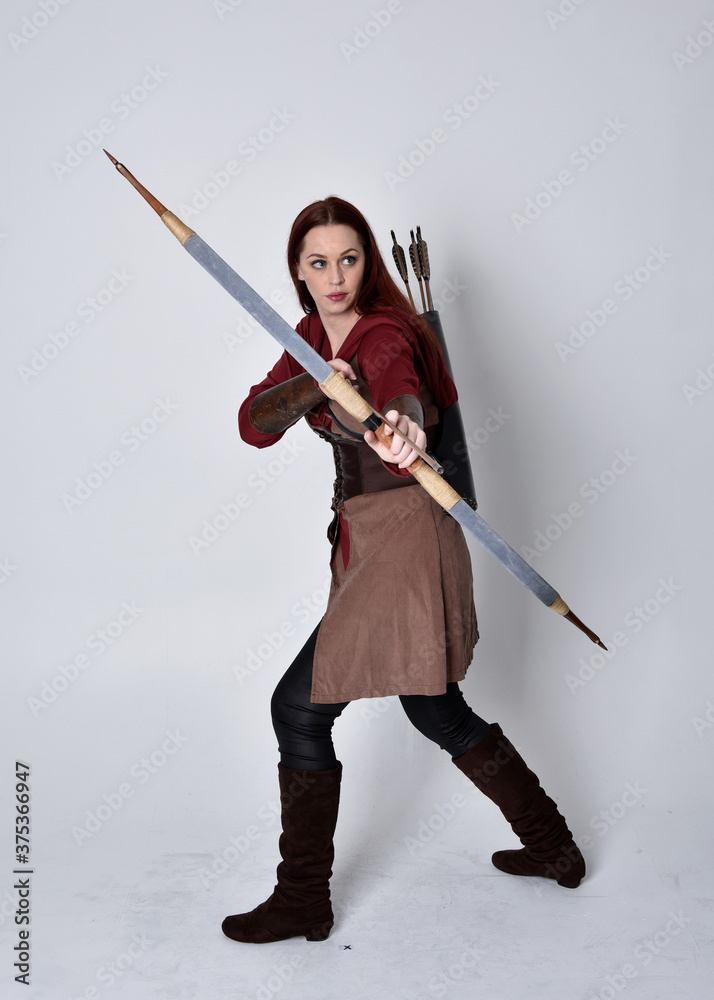 Full length portrait of girl with red hair wearing brown medieval ...