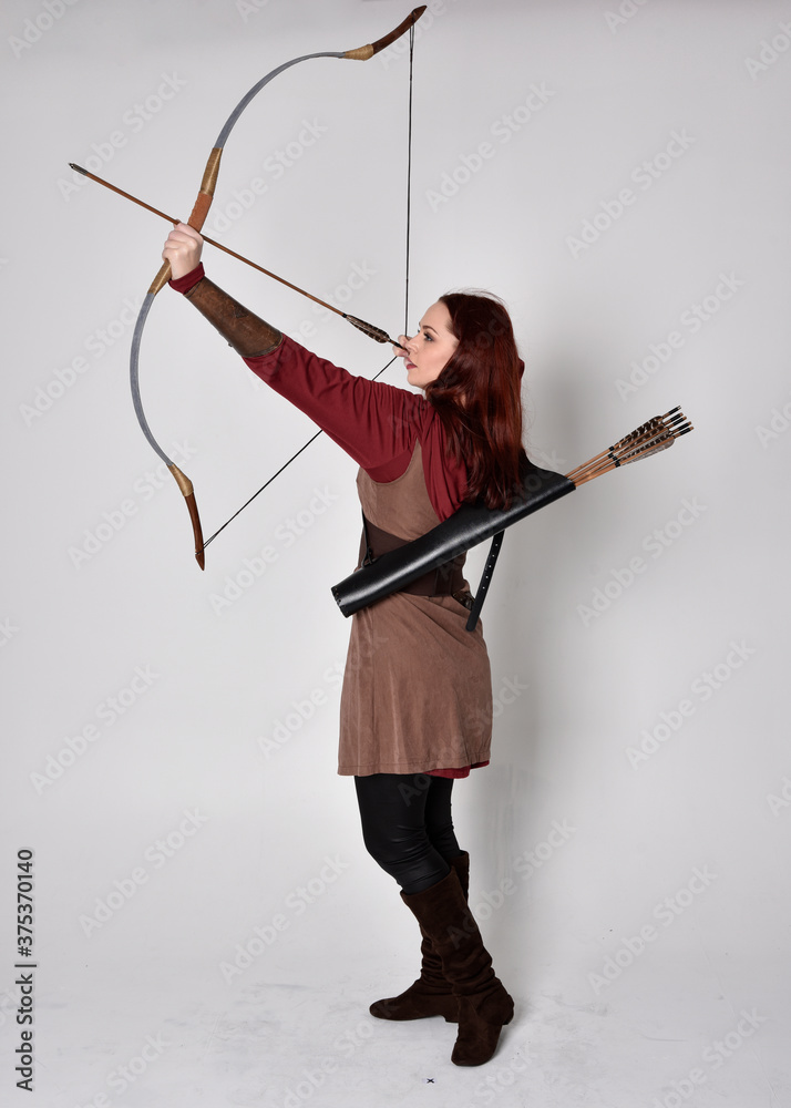 Full length portrait of girl with red hair wearing brown medieval ...