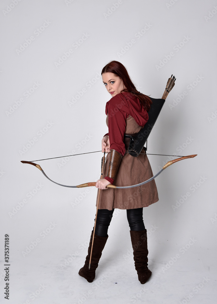 Full length portrait of girl with red hair wearing brown medieval ...