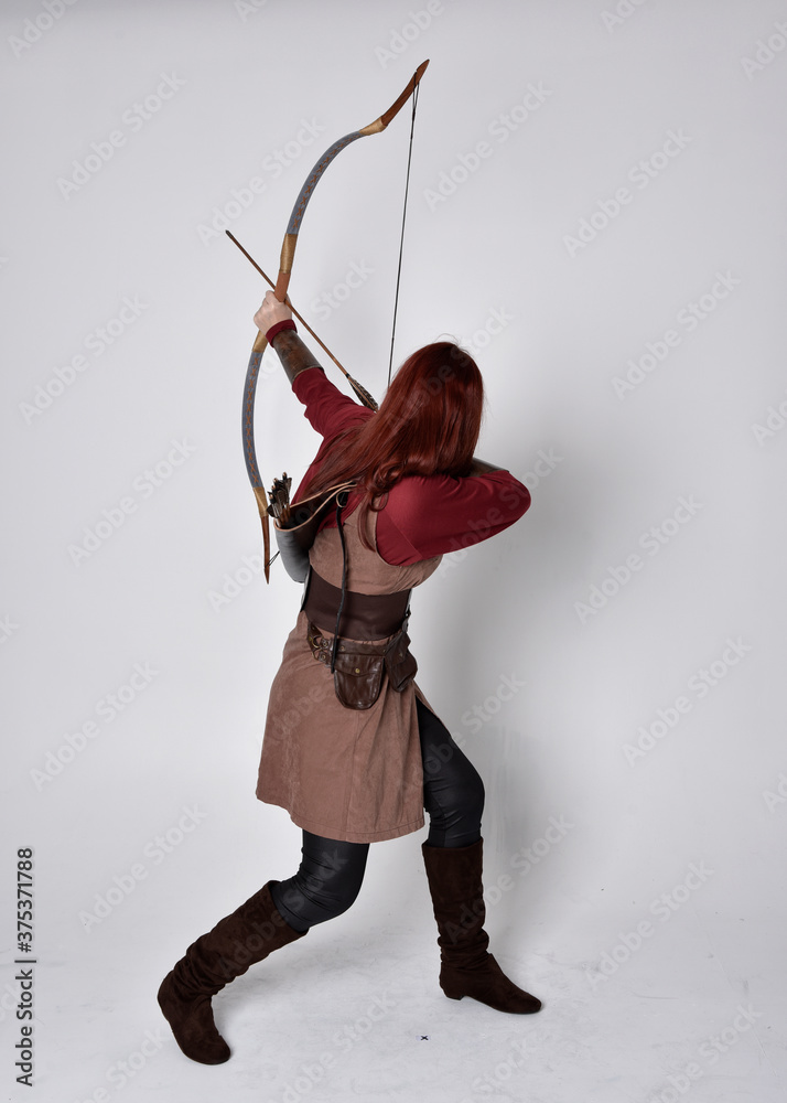 Full length portrait of girl with red hair wearing brown medieval ...