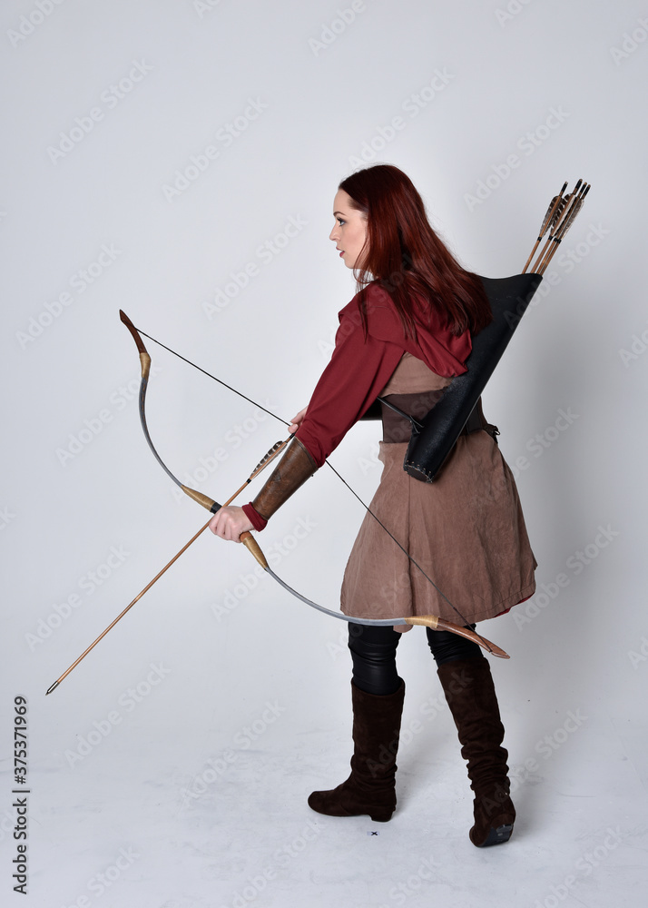 Full length portrait of girl with red hair wearing brown medieval ...