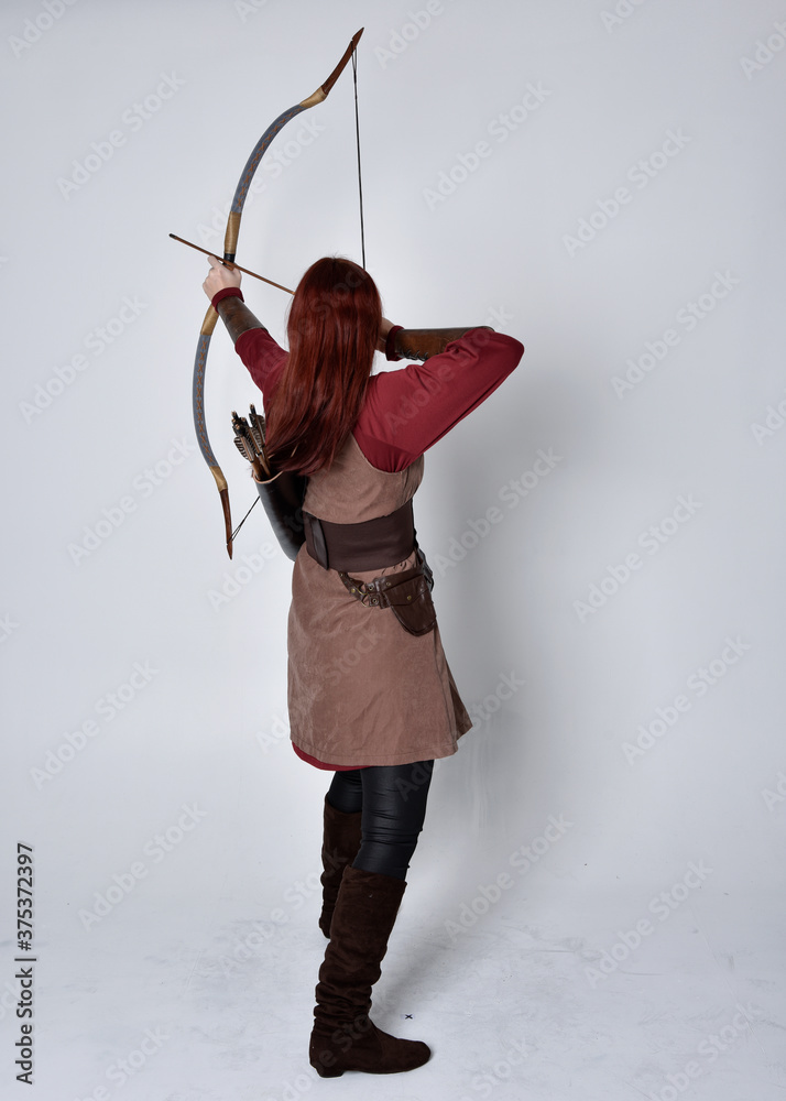 Full length portrait of girl with red hair wearing brown medieval ...