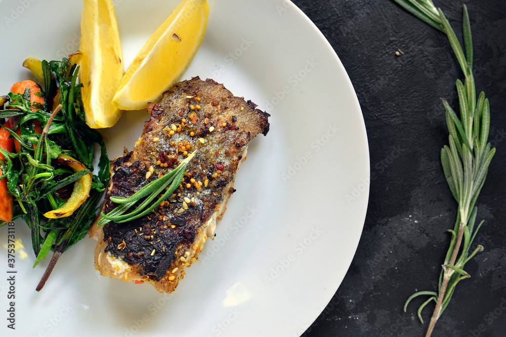 Grilled fish with lemon, herbs and rosemary. Fried fish fillets in a ...