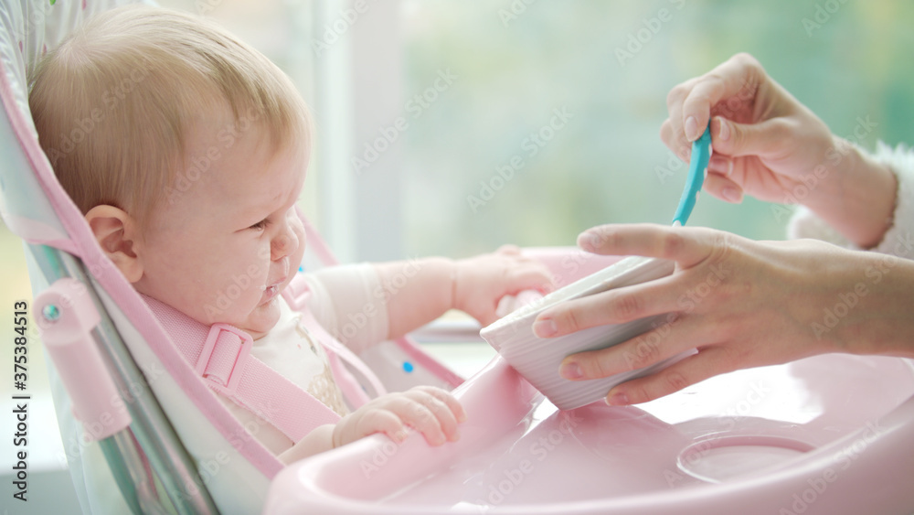 Sad baby dont want eating porridge. Little baby in chair not eating ...