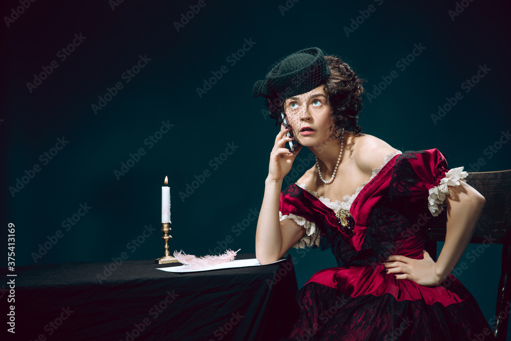 Wake up call. Young woman as Anna Karenina isolated on dark blue ...