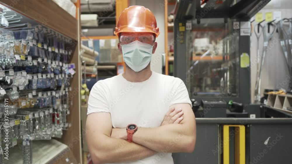 Caucasian industrial worker in orange hard hat, safety goggles and ...