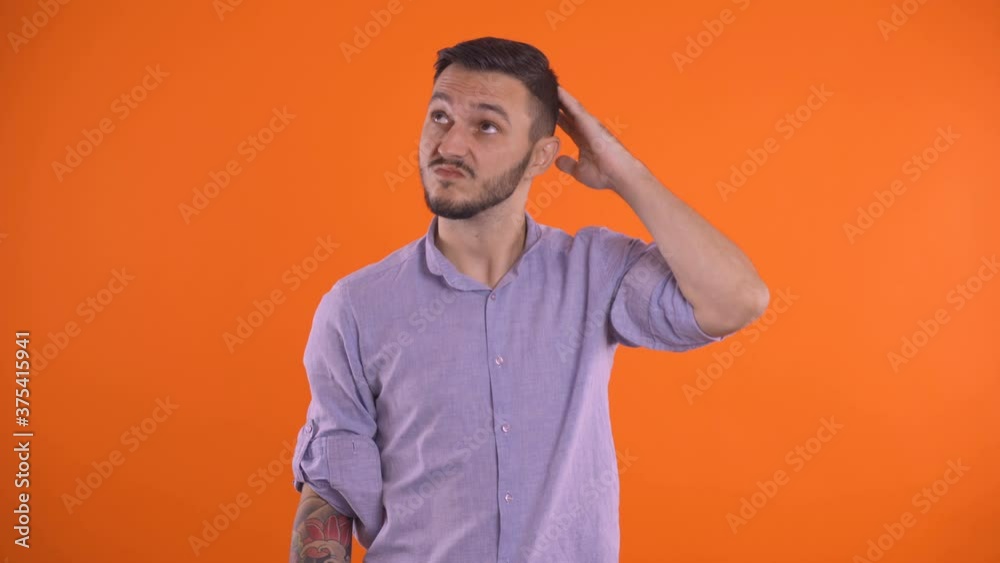 Guilty, embarrassed man scratching head thinking and rolling eyes up ...