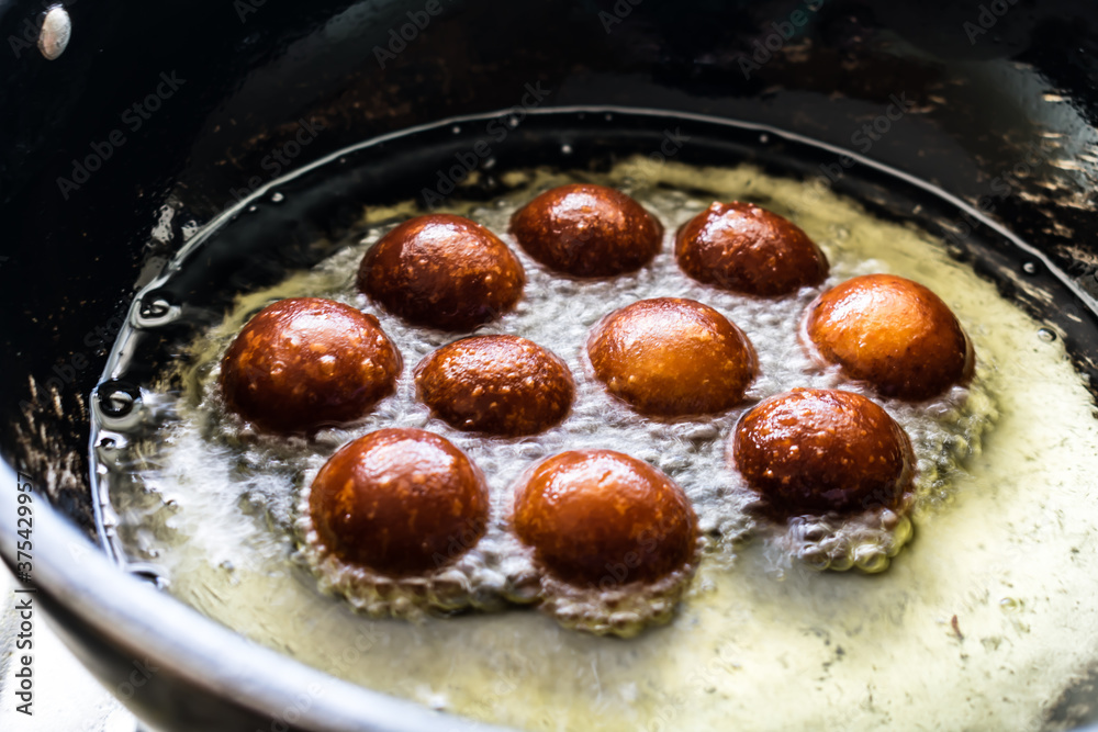 indian sweet julab jamun oil frying in pan for celebration of festival ...
