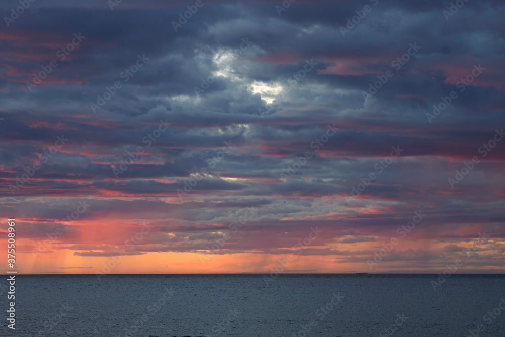 Foto de Skyscape of a sunset and grey clouds with little light going ...