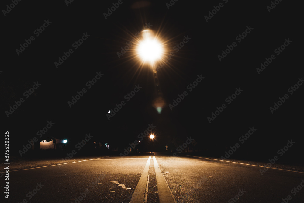 Foto de Perspective view of lane lines of an old asphalt road in a dark ...