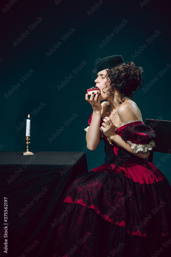Diet and sweets. Young woman as Anna Karenina isolated on dark blue ...