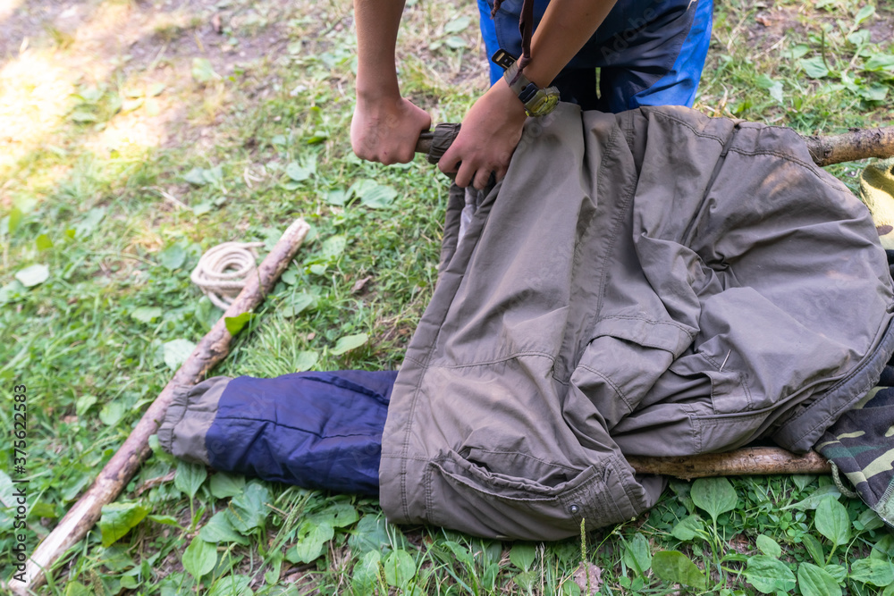 Fotka „The first medical aid. Scout boy making a sanitary stretcher out ...