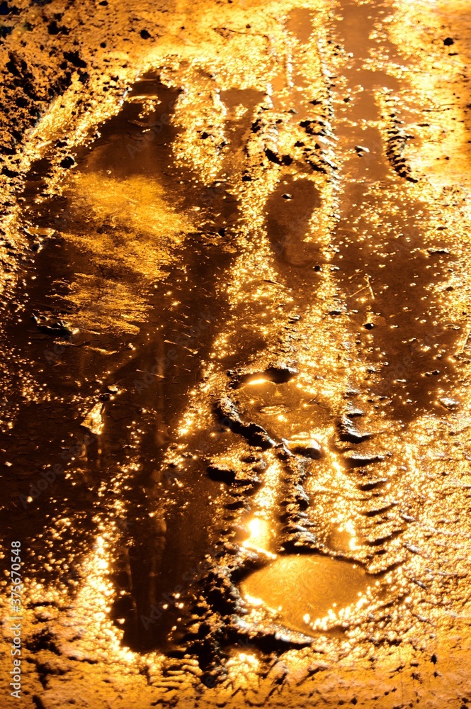 Muddy spot in an old damp tunnel with yellow light reflections. Thick ...