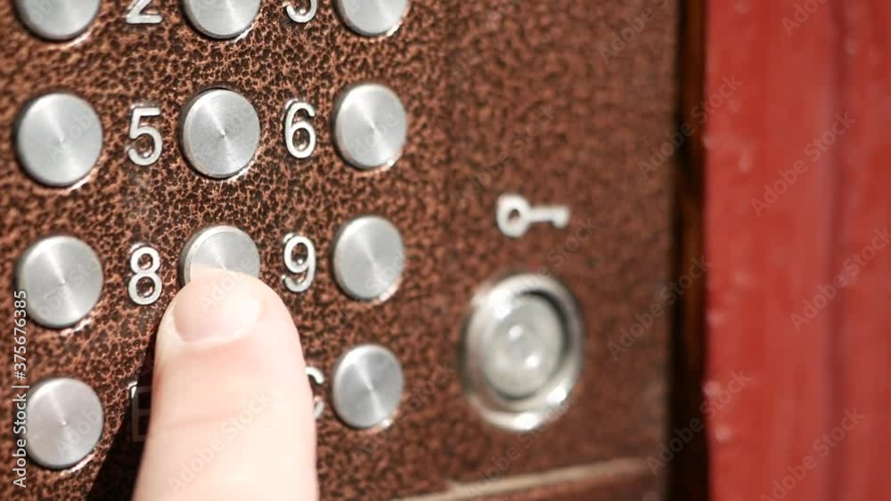 A finger presses the aluminum intercom buttons. A man hand enters a ...
