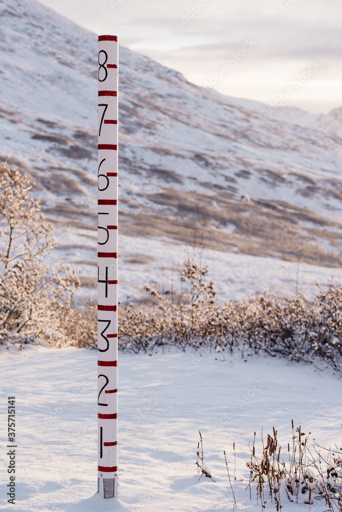 Less than a foot of snow measurement pole in Alaska Stock Photo | Adobe ...
