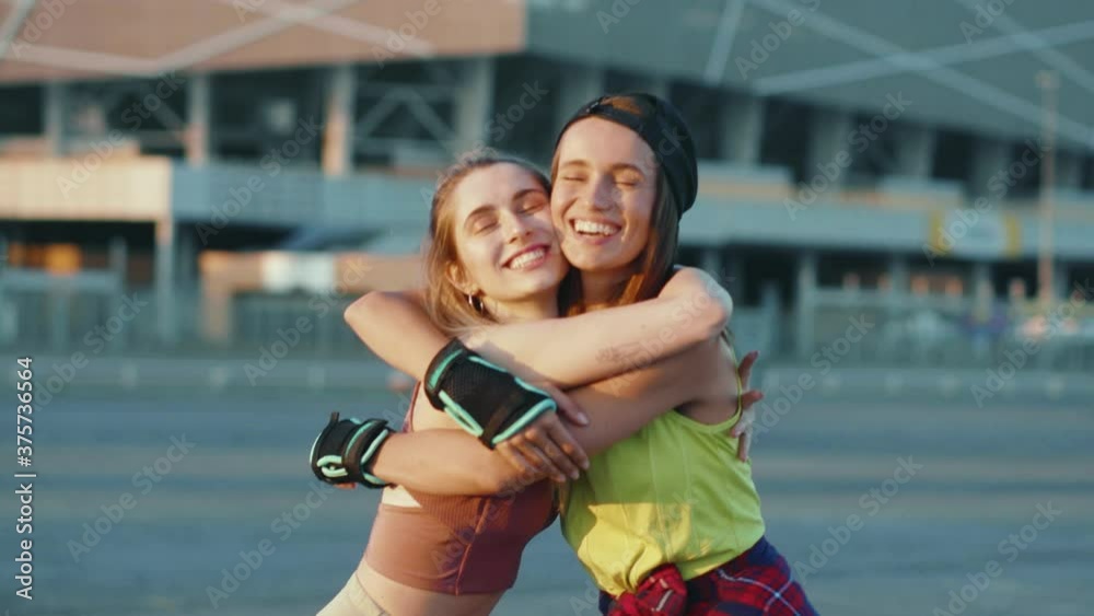 Attractive portrait of two pretty wooman look at camera stand hugging ...