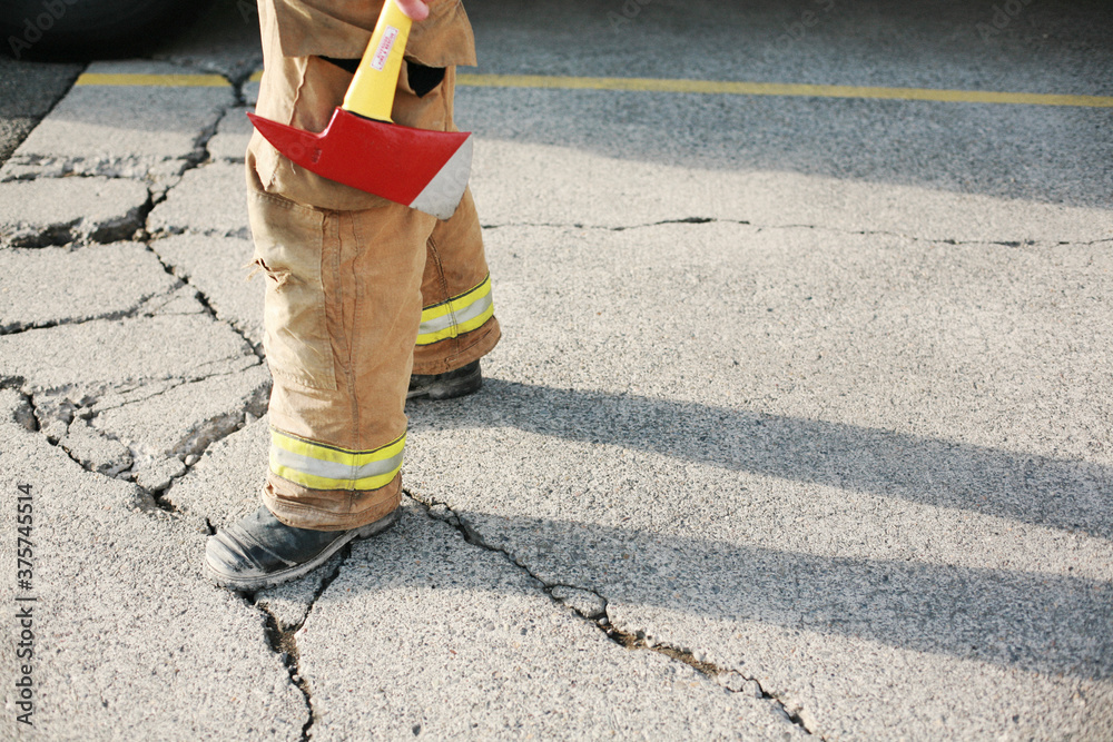 Firefighter holding axe Stock Photo | Adobe Stock
