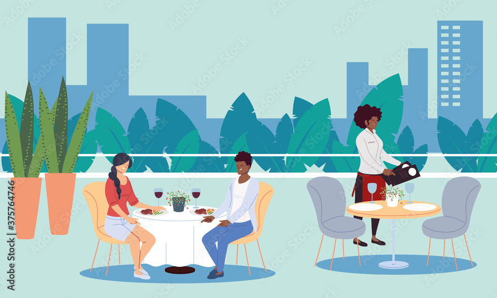 People dining in an upscale outdoor luxury restaurant and waiters ...