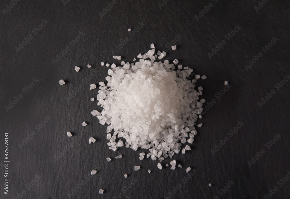 Pila de sal de mar grano grande sobre mesa de piedra negra. Stock Photo ...
