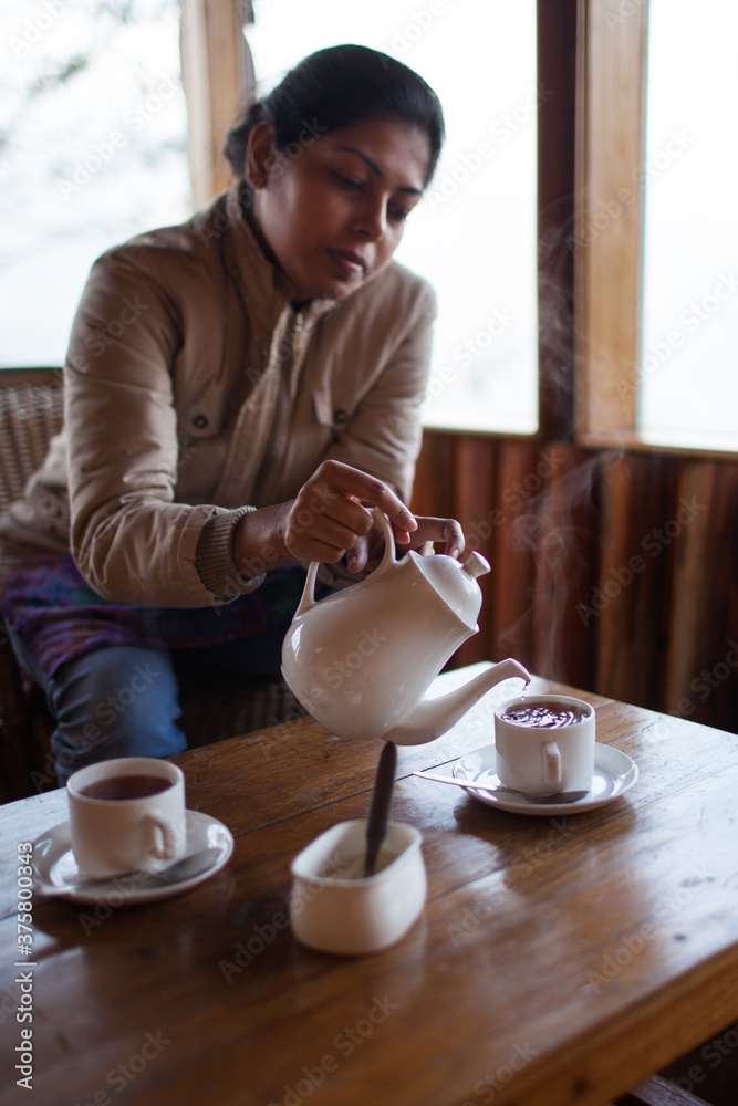 Woman pouring tea Stock Photo | Adobe Stock