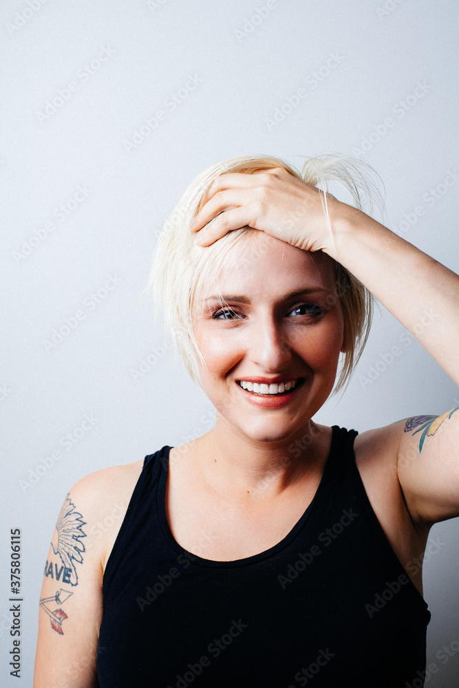 A 32 year old caucasian woman with blonde hair brushing her hair away ...