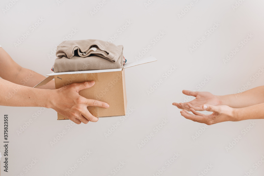 hand holding box give clothes together for concept donation and reuse ...