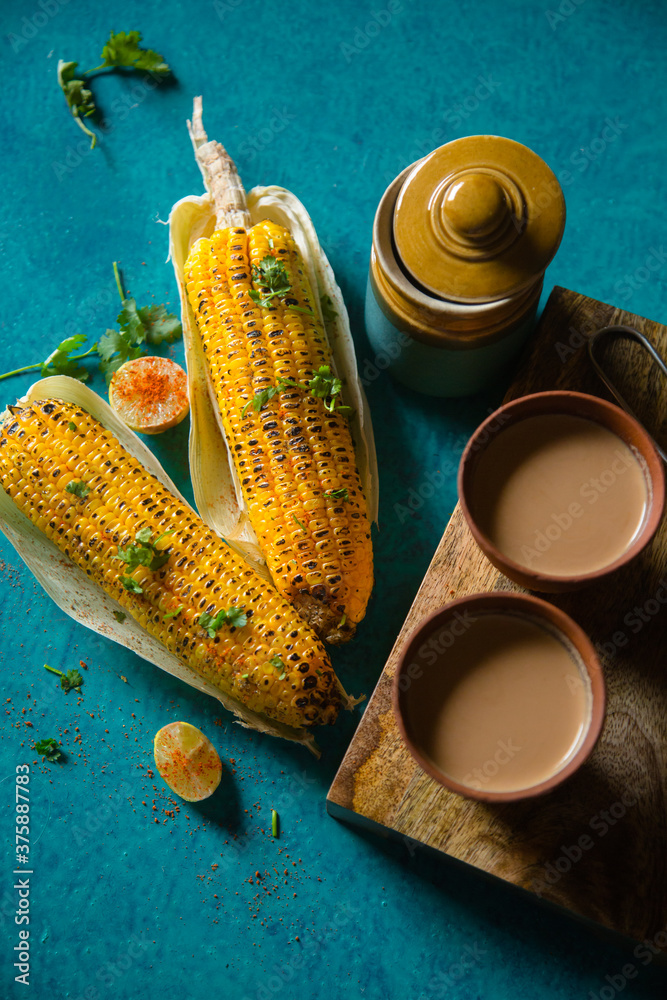 Top view of brewed hot milk tea with roasted grilled corn on blue ...