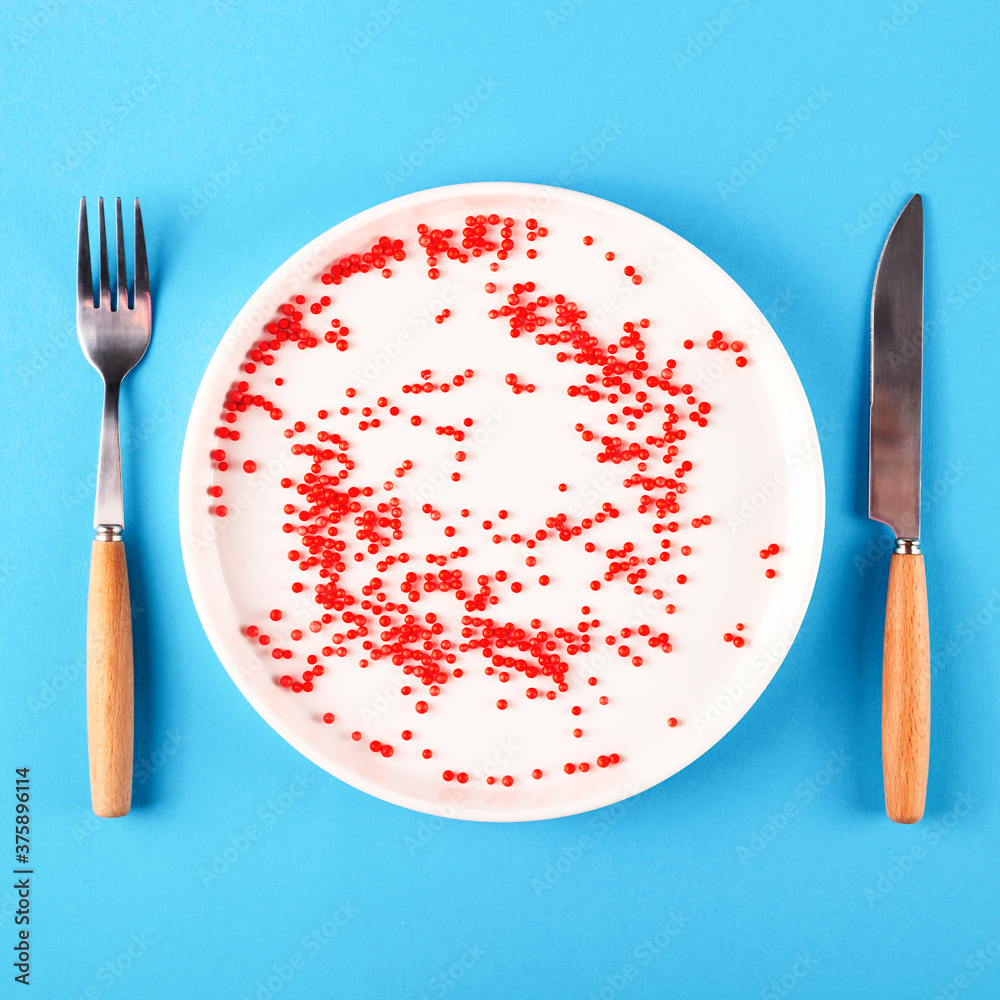 Plastic in a plate next to a knife and fork. The concept of ...
