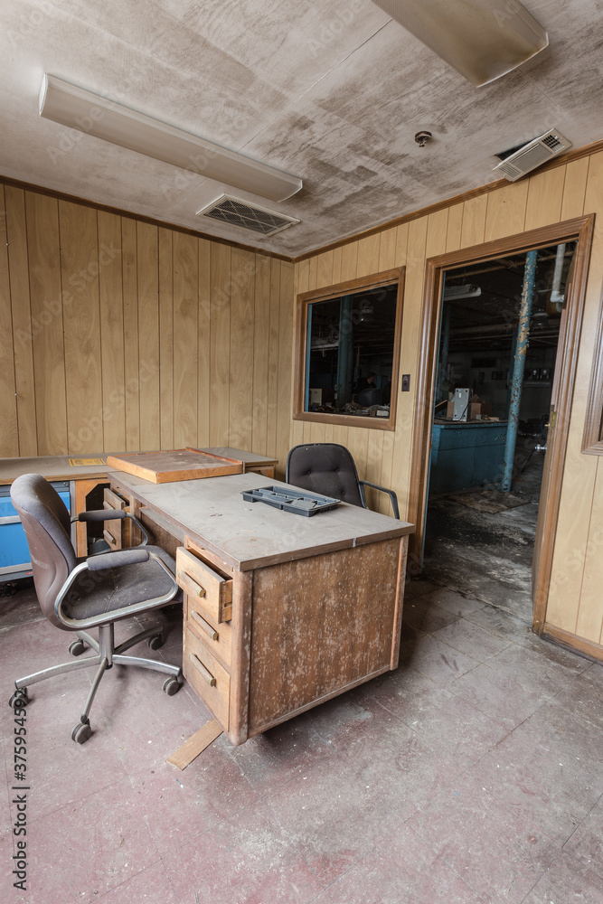 Empty office with desk covered in dust in an abandoned factory in the ...