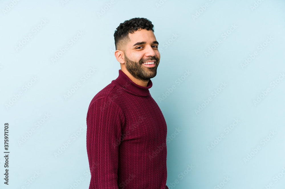 Young mixed race arabic man isolated looks aside smiling, cheerful and ...