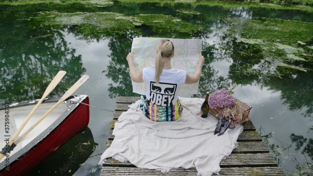 Woman unfolding map of area to look at next destination sitting on ...