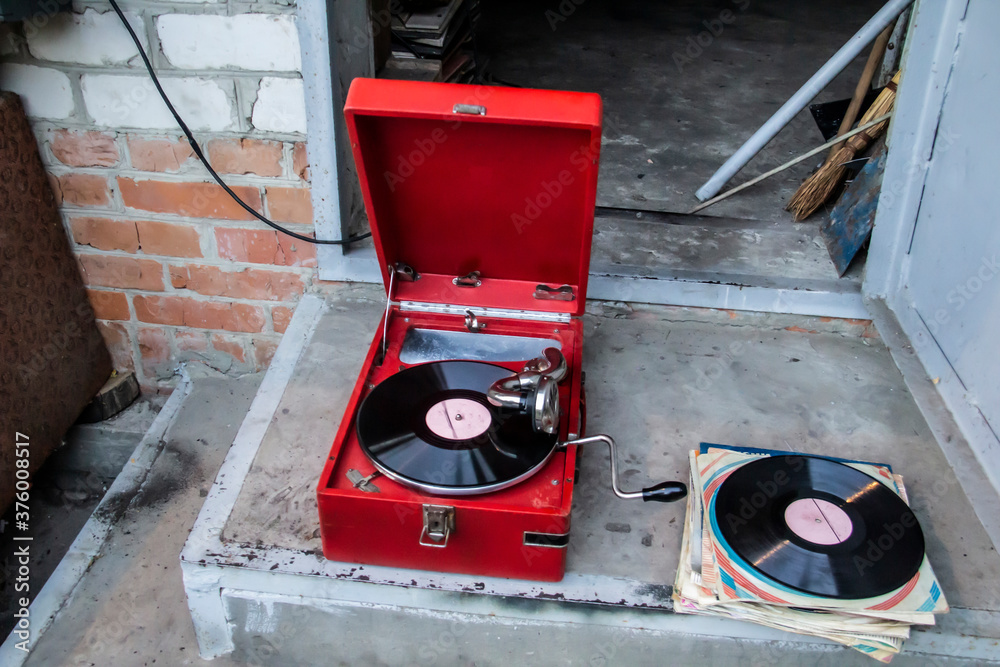 Old red vintage record player with vinyl record outside house. Old ...