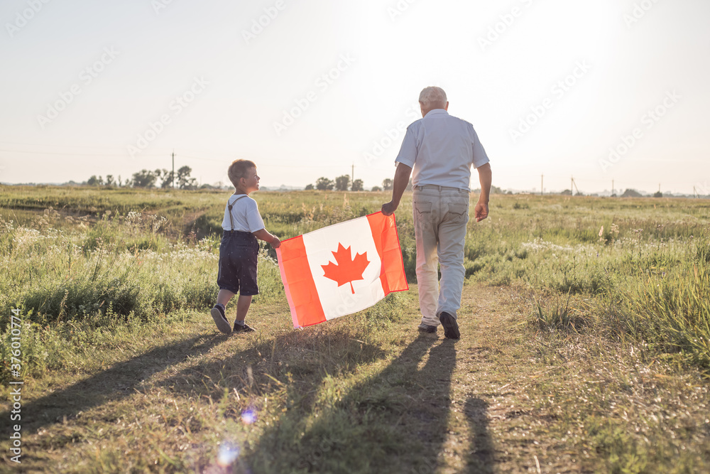 Attractive old senior man and grahdson holding Canadian Flag. National ...