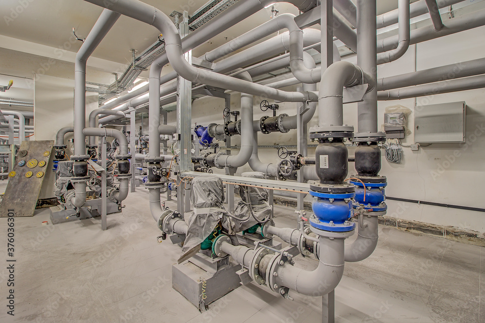 Mounting red and green piping. Installation of fittings in basement of ...