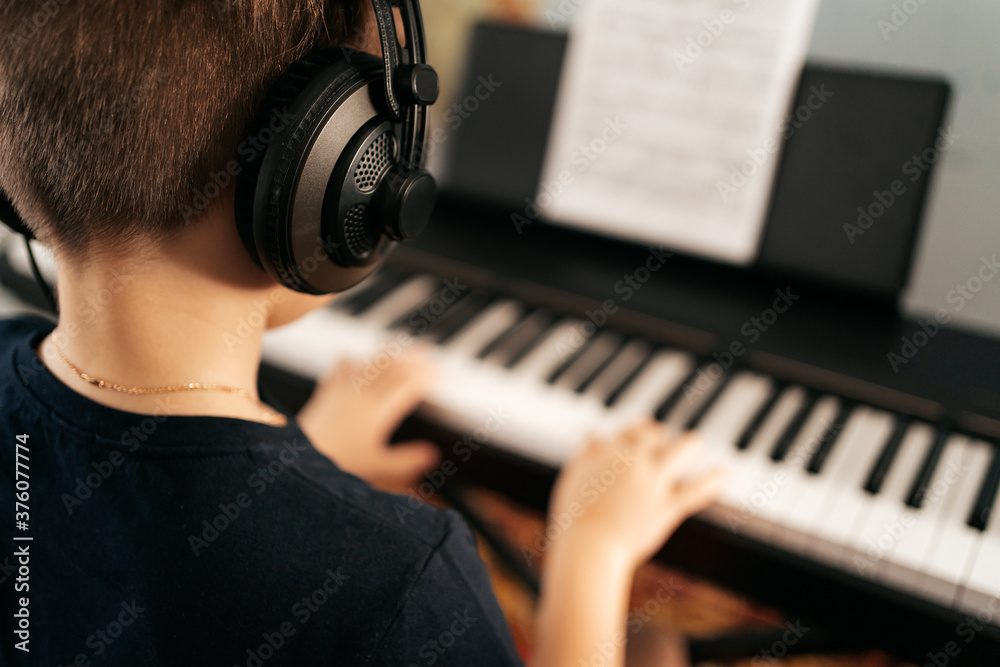 Young boy sitiing at digital piano. Playing keyboard, focused kid have ...