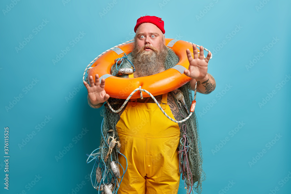 Scared bearded fiisherman afraids of swimming, raises palms in ...