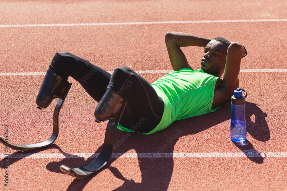 Black African American Male athlete with prosthetic legs laying on race ...