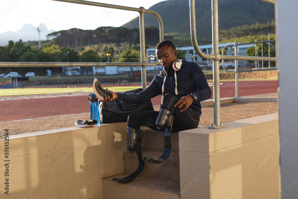 Black African American Male athlete with prosthetic legs sitting on ...