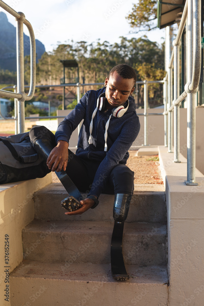 Black African American Male athlete touching his prosthetic leg while ...