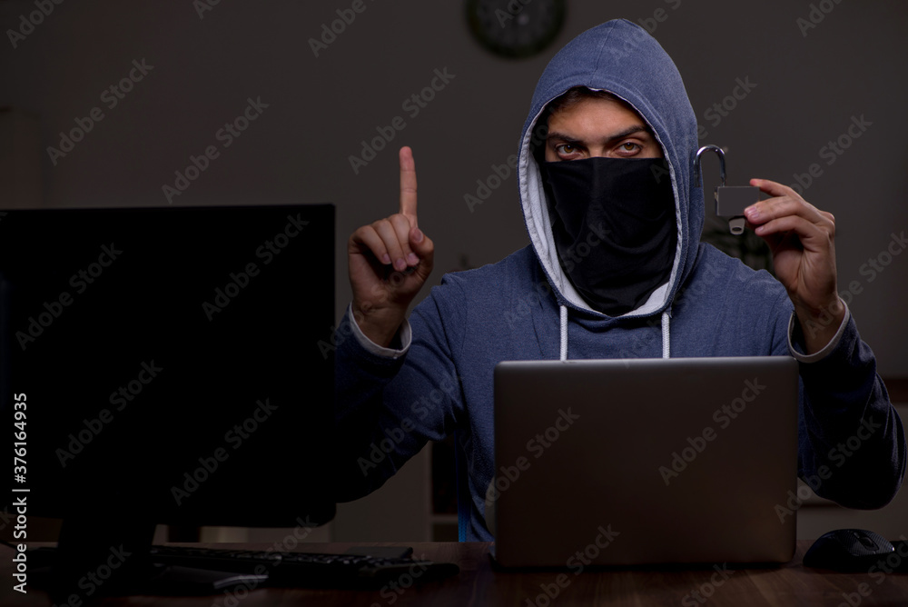 Male hacker hacking security firewall late in office Stock Photo ...