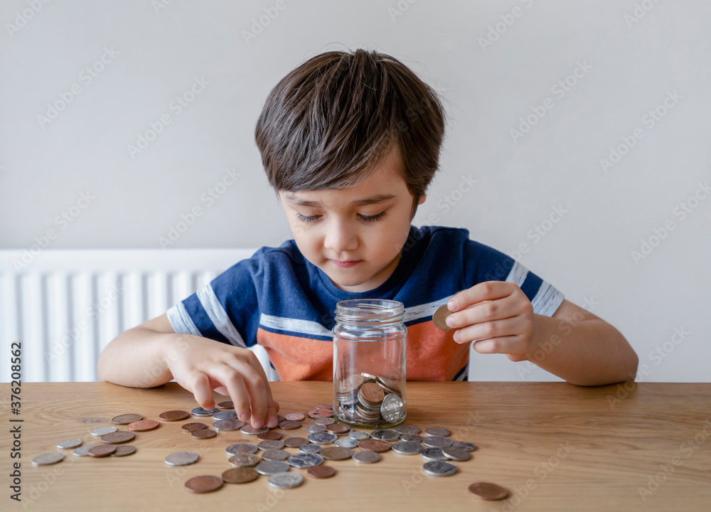 School Kid putting money coins into clear jar, Child counting his ...