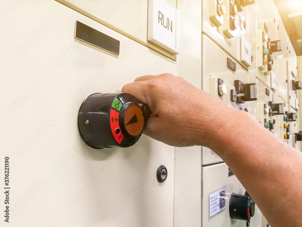 Hand holding the control panel of the industrial plant and pushing or ...