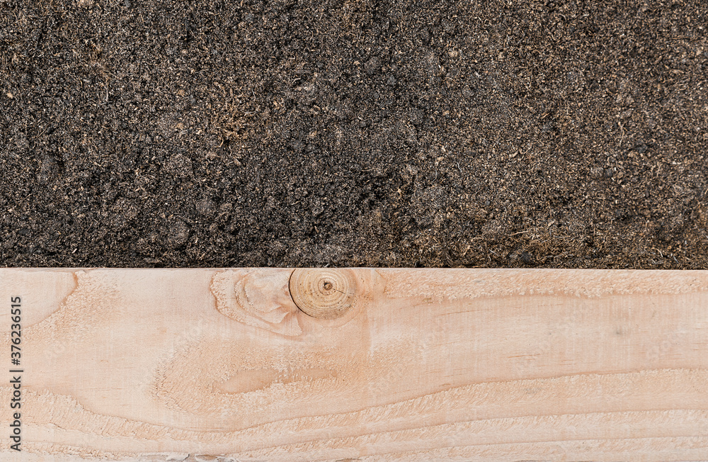 Seamless wooden raised bed border edge next to freshly laid compost ...