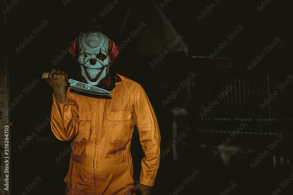 Asian handsome man wear clown mask with weapon at the night scene ...
