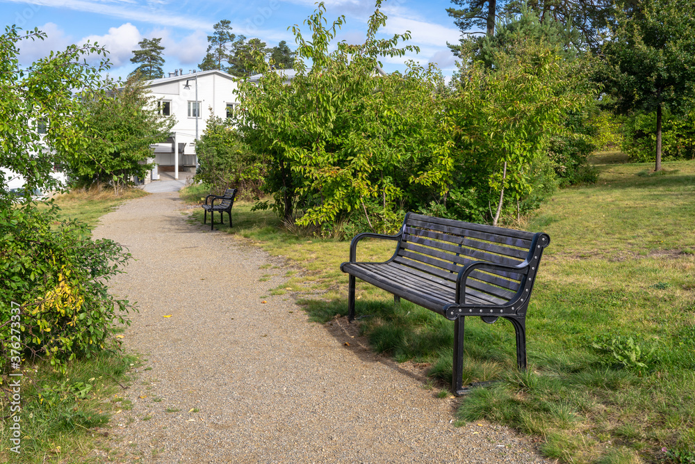 Foto de Bench in the garden. Old wooden bench with metal handrail and ...